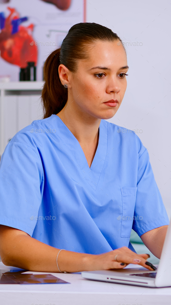 Medical practitioner typing patient health report on laptop Stock Photo ...