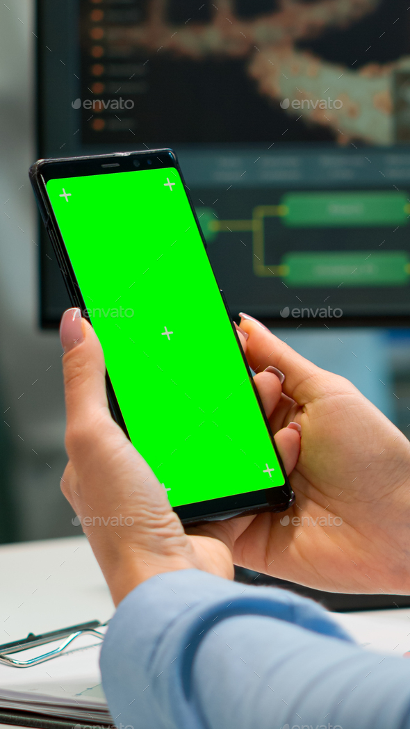 Medic in scientific laboratory holding phone with green screen Stock ...