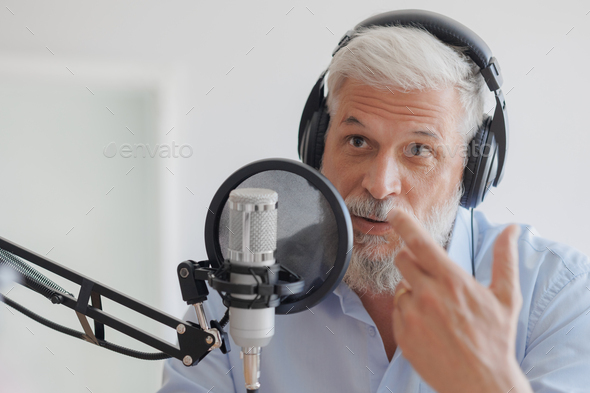 older man with gray hair irecording podcast in recording studio with ...