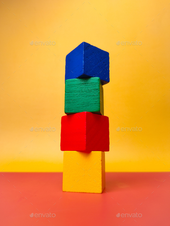 Colored wooden blocks that have been arranged on a yellow background ...