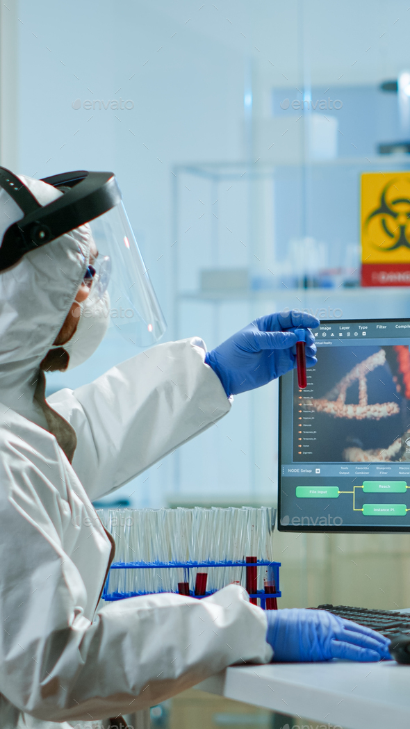 Biotechnology scientist wearing ppe suit researching in equipped ...