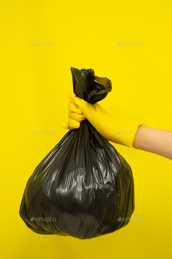 Cleaner concept, Hand in rubber gloves and holding plastic bag with ...