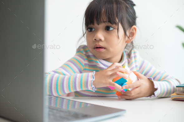 Asian little cute girl holding Rubik's cube in her hands. Rubik's cube ...