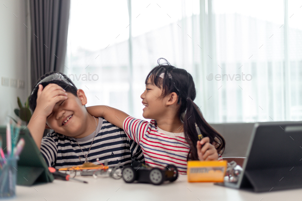 two Asian children having fun learning coding together, learning ...