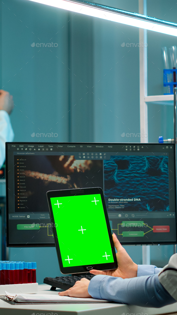 Microbiologist working on notepad with green chroma key display Stock Photo by DC_Studio
