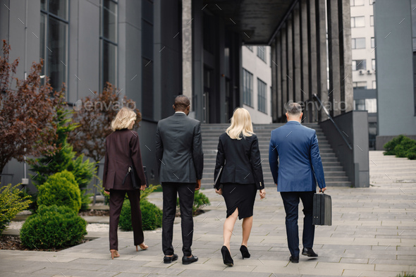 Backside photo of a business people walking toward modern office Stock ...