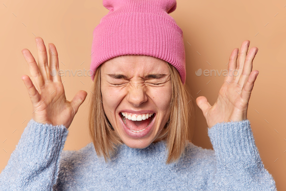 Emotional angry teenage girl exclaims loudly raises palms and reacts ...