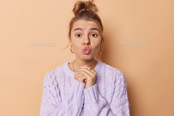 Horizontal shot of lovely young woman keeps lips folded feels romantic ...