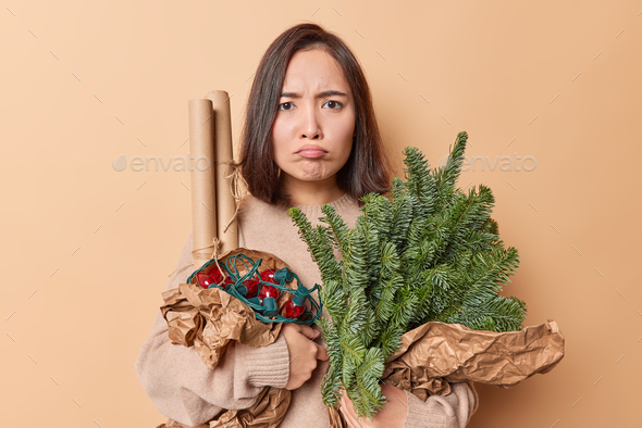 Upset disappointed Asian woman purses lips feels unhappy poses with ...