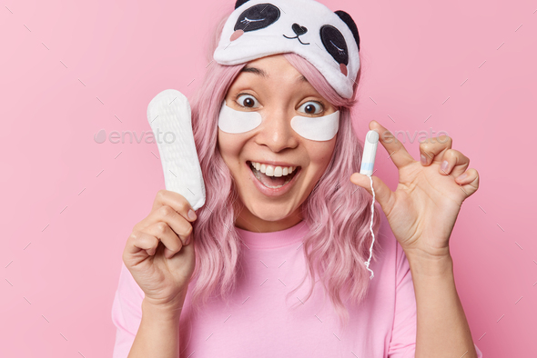 Photo Of Surprised Young Asian Woman With Toothy Smile Looks Happily Holds Tampon And Sanitary