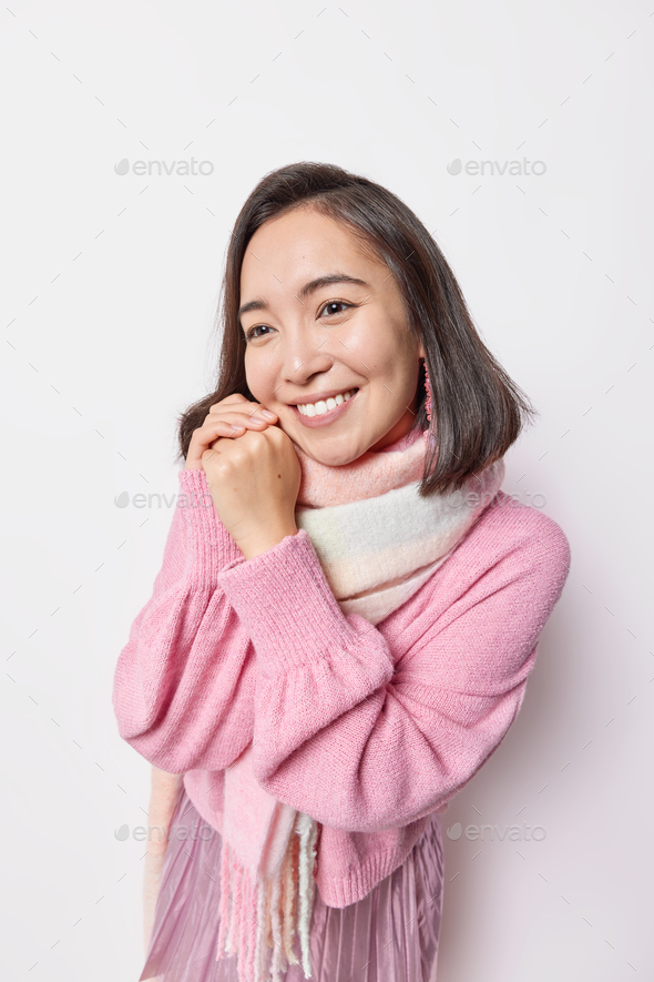 Photo of nice looking Asian woman smiles gently keeps hands near face ...