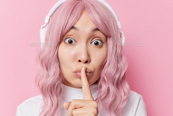 Headshot of surprised pink haired young Asian woman shares secret keeps ...