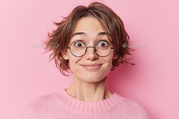 Headshot of surprised happy woman stares through glasses cannot believe ...