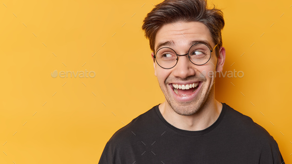 Positive smiling guy looks away laughs at something funny smiles ...