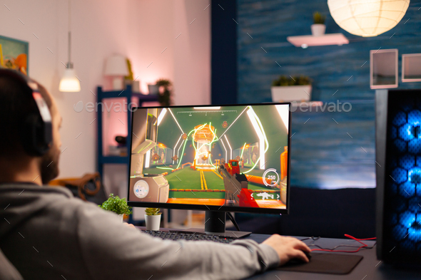 Pro virtual gamer wearing headphones playing video game Stock Photo by ...