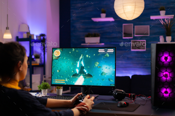 Concentrated player sitting on gaming desk late at night Stock Photo by ...