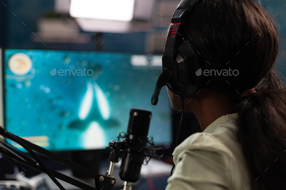 Concentrated pro gamer talking into microphone during live streaming ...