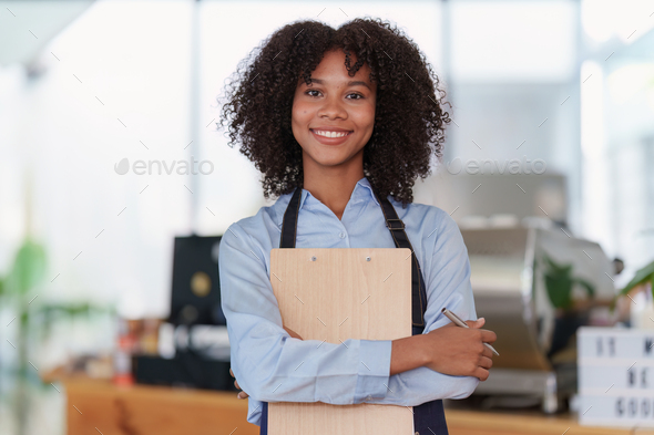 Young Female manager in restaurant with notebook. Woman coffee shop ...