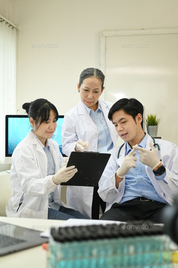 Professional scientists wearing white coats conducting experiment in ...