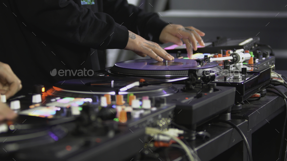 DJ spinning record at disco. Art. Close-up of DJ's hand on mixer ...