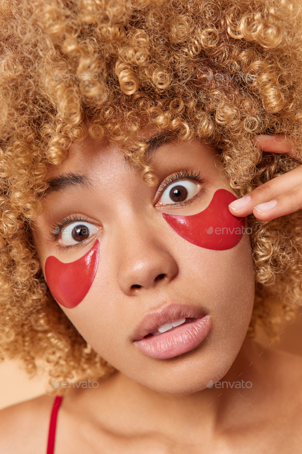 Close up portrait of surprised young woman stares bugged eyes at camera ...