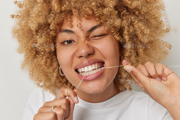 Tooth care routine concept. Close up portrait of curly haired woman ...