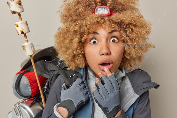 Photo of shocked curly female camper stares bugged eyes with startled ...