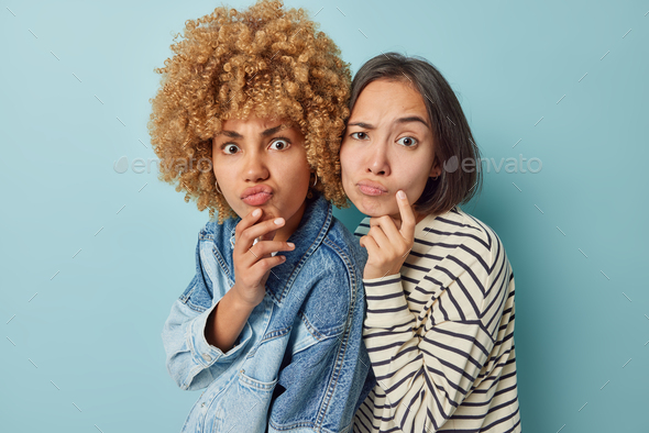 Portrait of two women pout lips focused at camera with serious ...