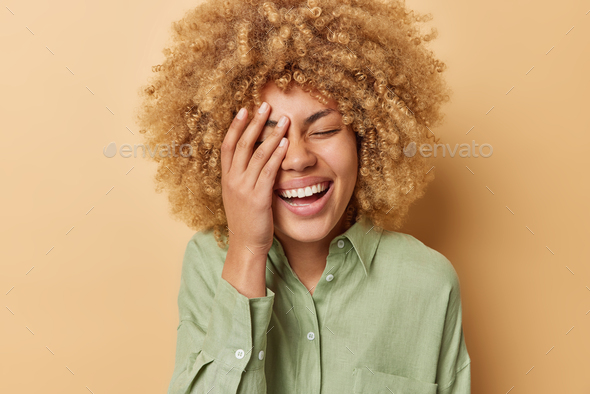 Happy cheerful woman makes face palm laughs joyfully expresses sincere ...