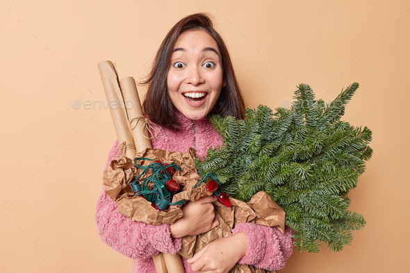 Indoor surprised Asian woman has overjoyed expression laughs gladfully ...