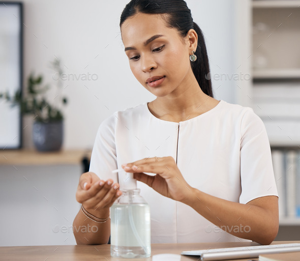Business woman sanitizing her hands in an office for hygiene, stop ...