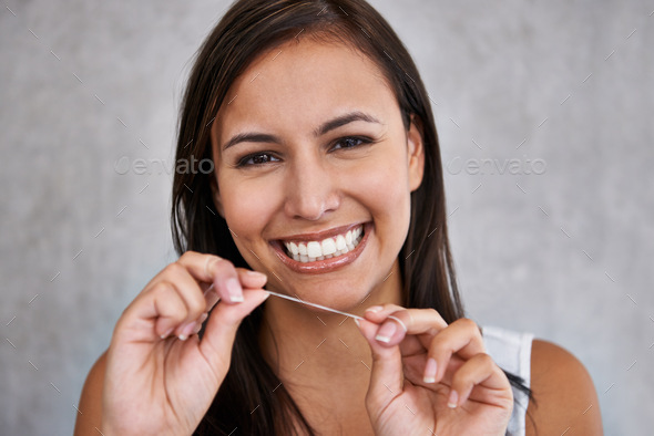 Only floss the teeth you want to keep. An isolated portrait of a young ...