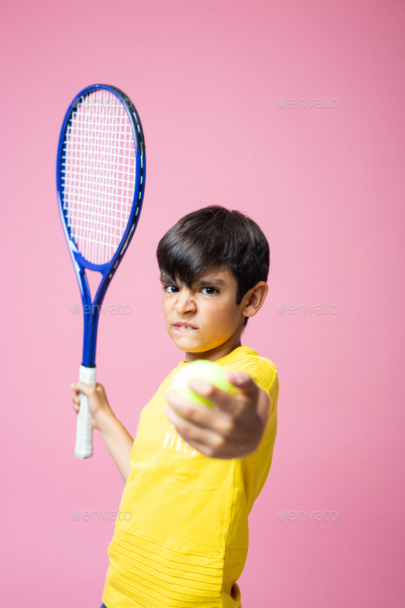 Boy with angry face using tennis racket and ball Stock Photo by riderfoot