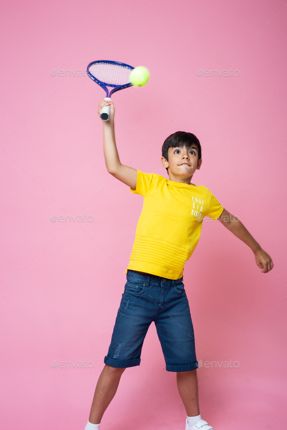 Boy playing tennis with a racket and a ball Stock Photo by riderfoot