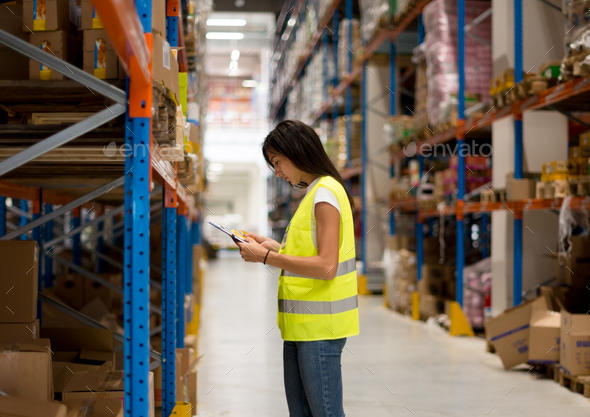 Workers in warehouse review the goods Stock Photo by StockRocketStudio