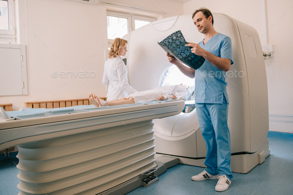 attentive doctor looking at tomography diagnosis while radiologist ...