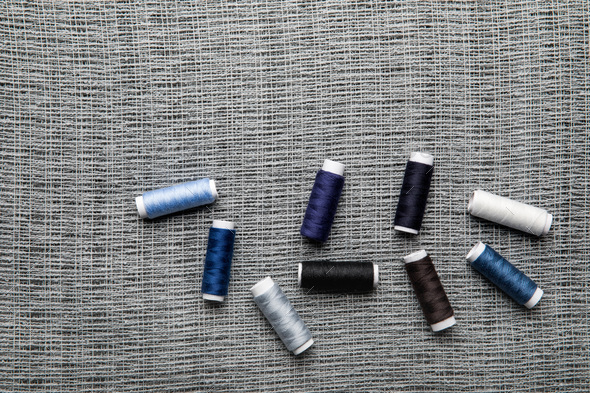 top view of scattered blue and grey thread coils on sackcloth with copy ...