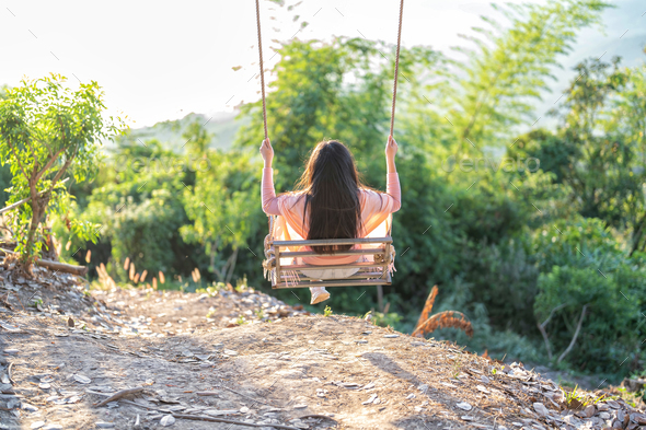 Sunshine morning traveler girl sit swinging hang from tree swing on ...