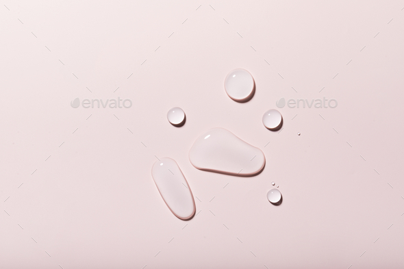 Top view closeup of multiple water drops on a light purple background ...