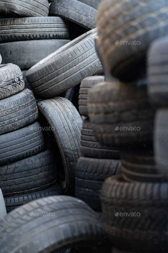 Old used rubber tires stacked with high piles. Hazardous waste ...