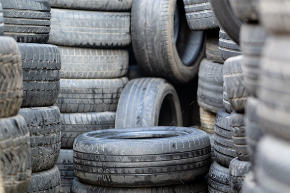 Old used rubber tires stacked with high piles. Hazardous waste ...