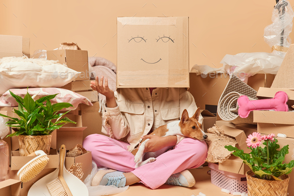 Faceless woman poses with carton box on head foolishes around draws ...
