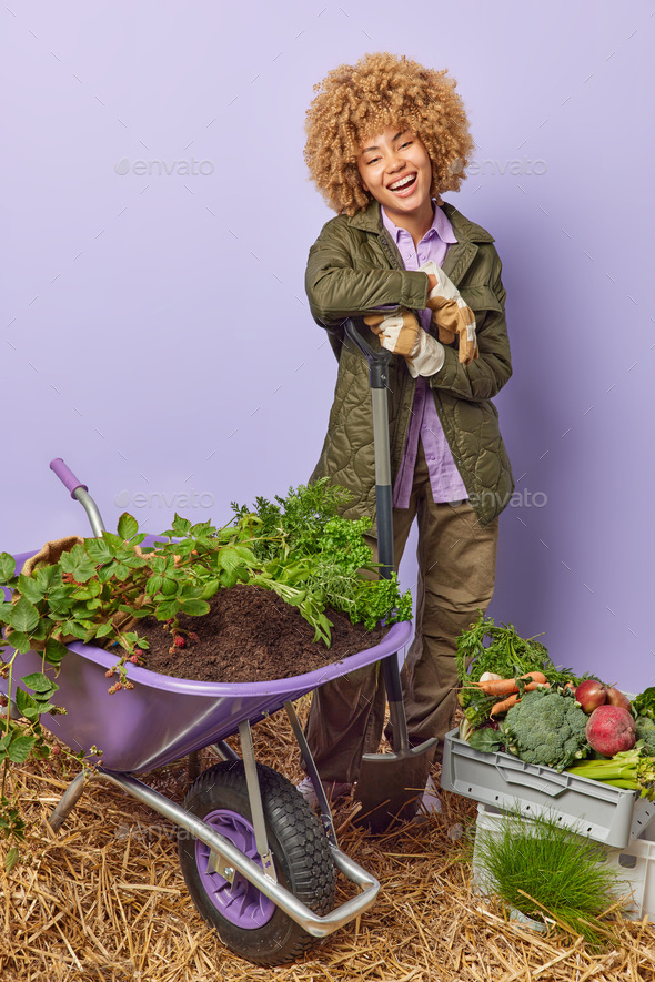 Happy farmer takes break while working in garden poses with shovel ...
