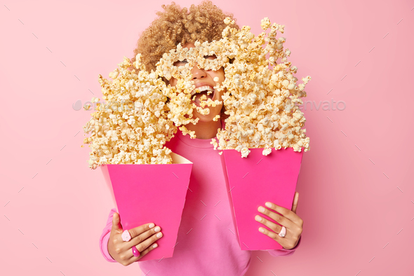 Photo of positive woman holds two paper buckets with spilled out ...