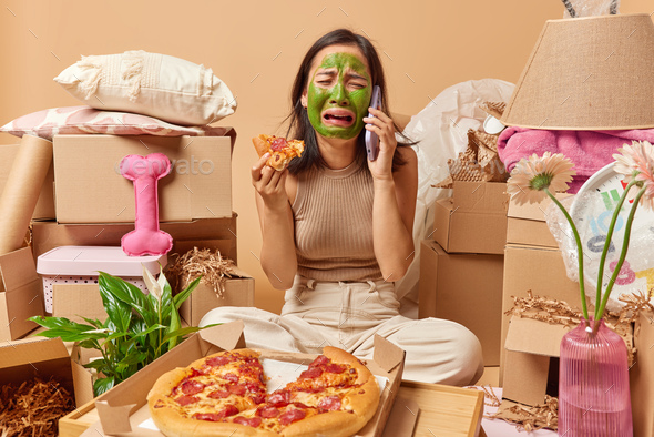 Photo of Asian woman applies green nourishing mask undergoes beauty treatments makes phone call ...