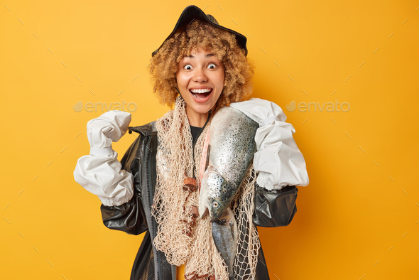 Emotional surprised woman holds big fish shocked with fine catch stares ...