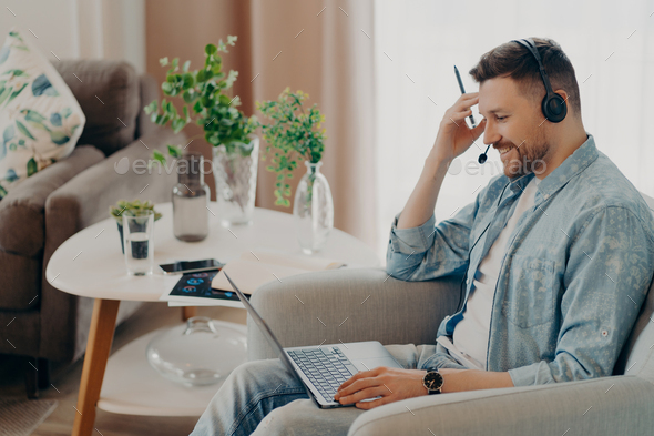 Smiling handsome man staring intently at laptop screen at home Stock ...