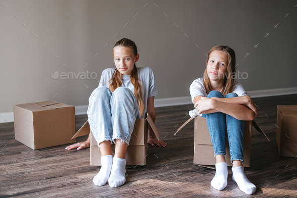 Young teen girls moving in new house with cardboard boxes Stock Photo ...