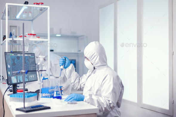 Doctor taking carefully sample from test tube using automatic pipette ...