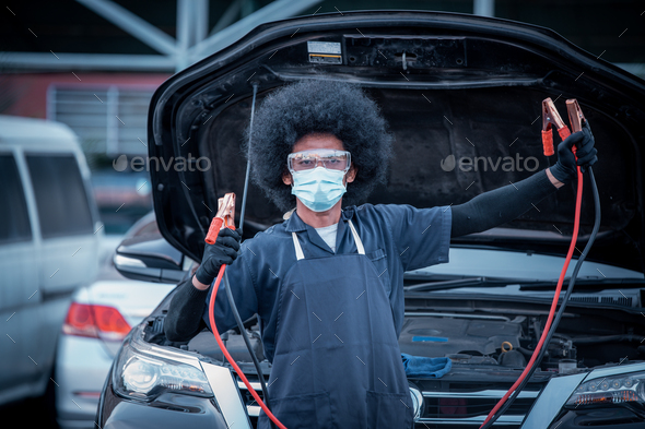Mechanic opens car hood to use the battery charger cable charge ...